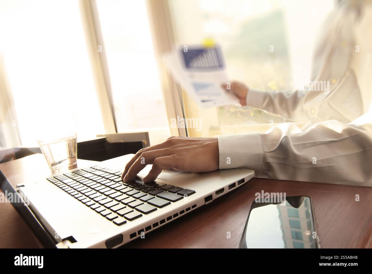 business man hand working on laptop computer on wooden desk as concept ...