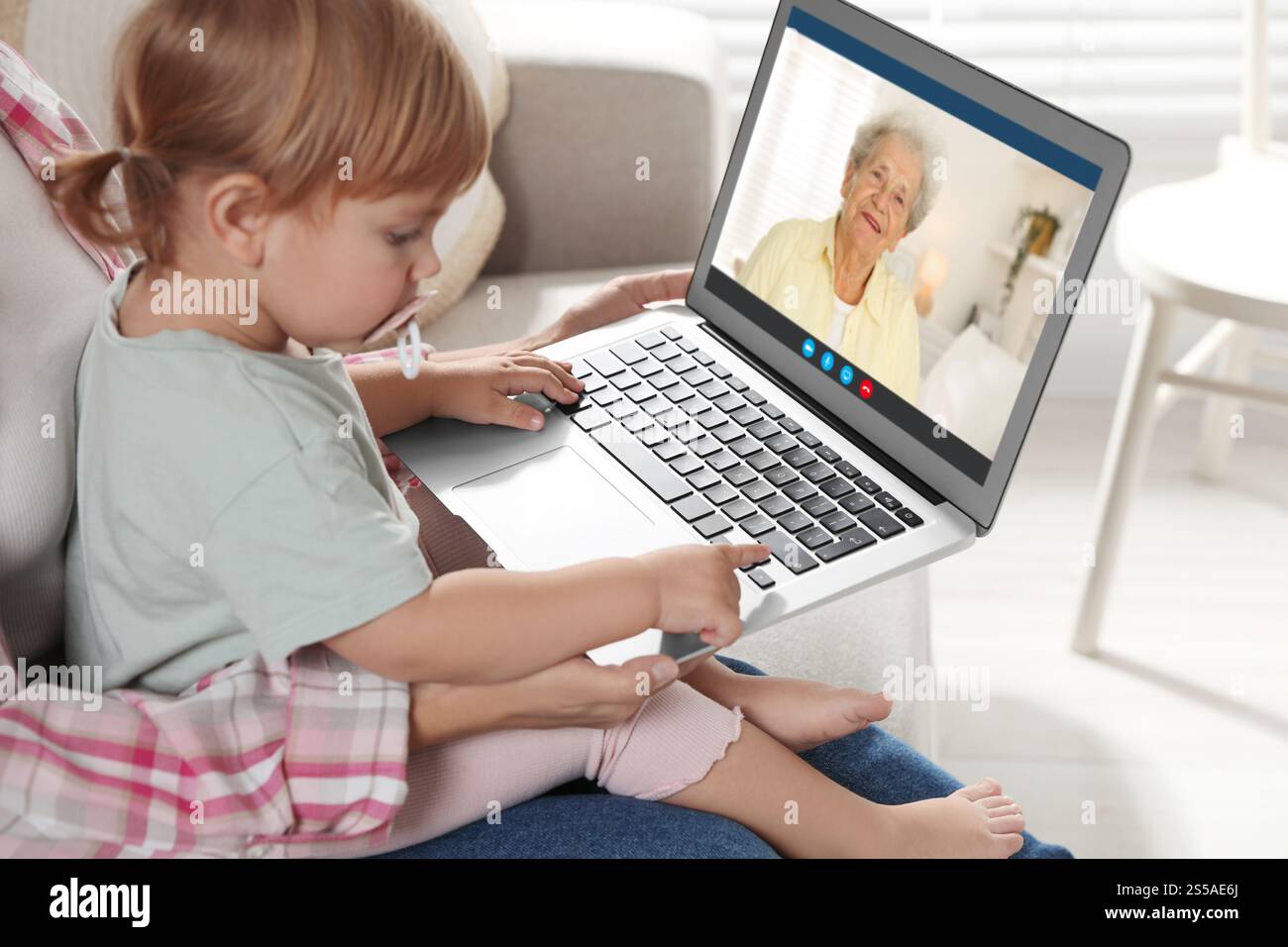 Grandmother and her daughter with granddaughter talking via video call ...