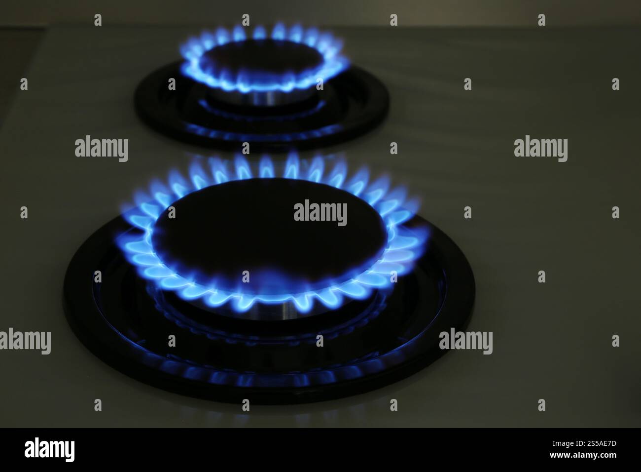 Modern gas cooktop with burning blue flames in kitchen at night Stock ...