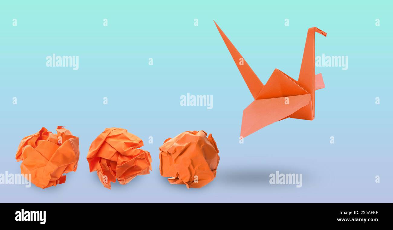 Orange origami crane and crumpled paper balls on blue gradient ...
