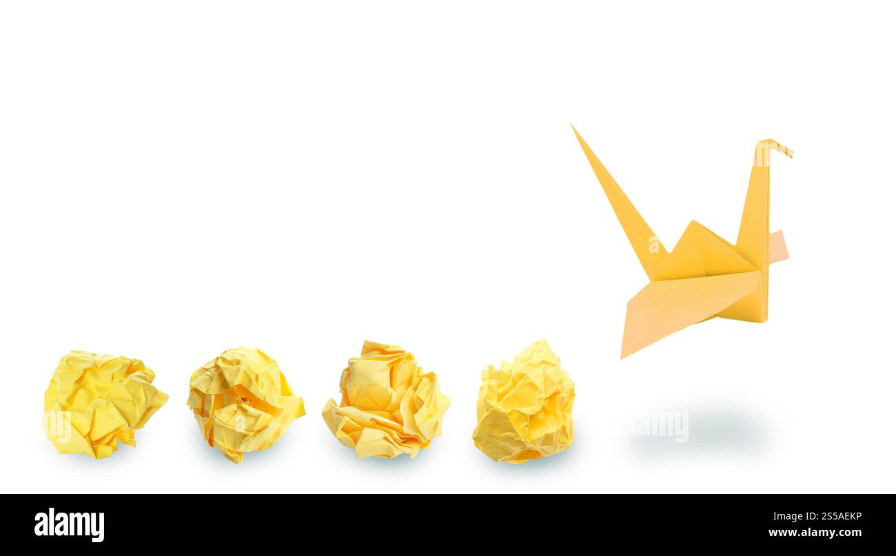 Yellow origami crane and crumpled paper balls on white background ...