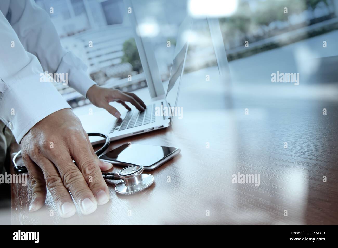 Doctor working with digital tablet and laptop computer in medical ...