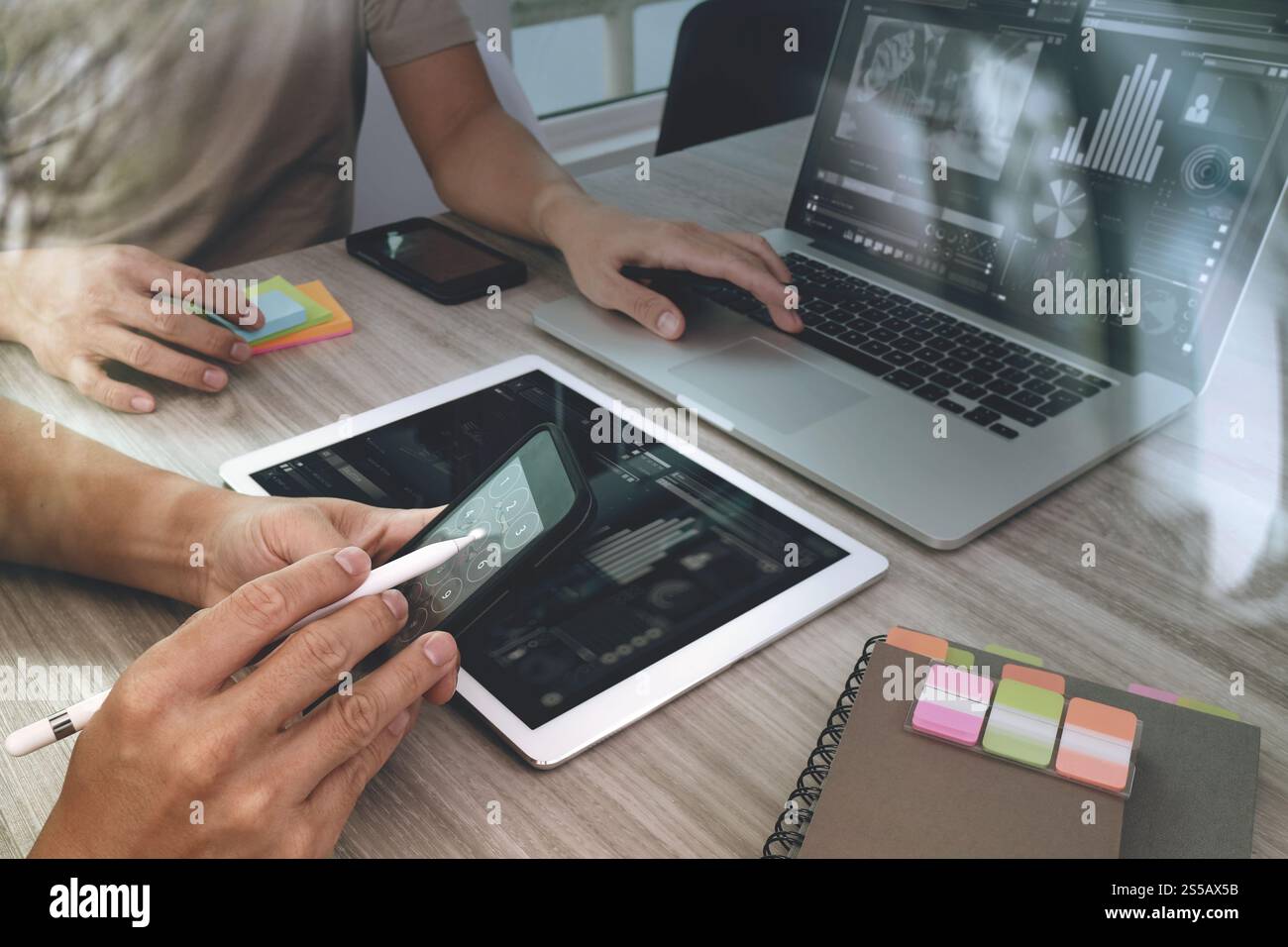 Designer hand working with digital tablet computer and smart phone making a presentation with ...