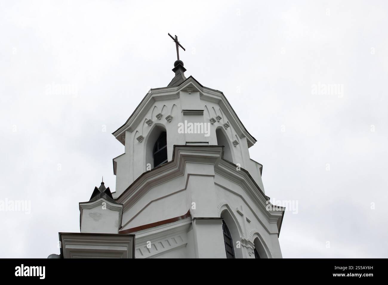 A pristine, white building that prominently features a cross adorning ...