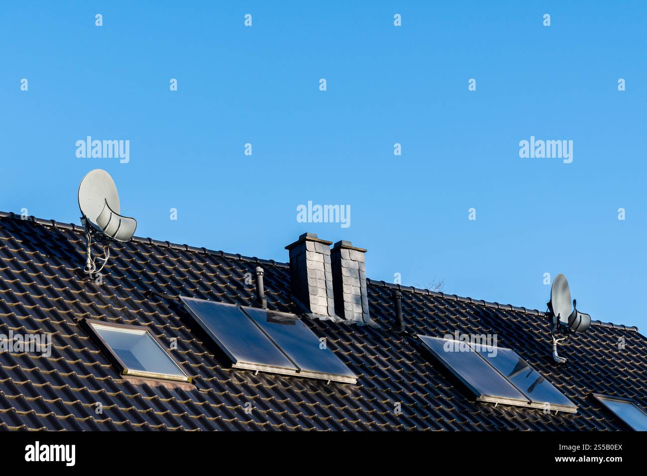 Solar panels are installed on the slanted roof of a house, complemented ...