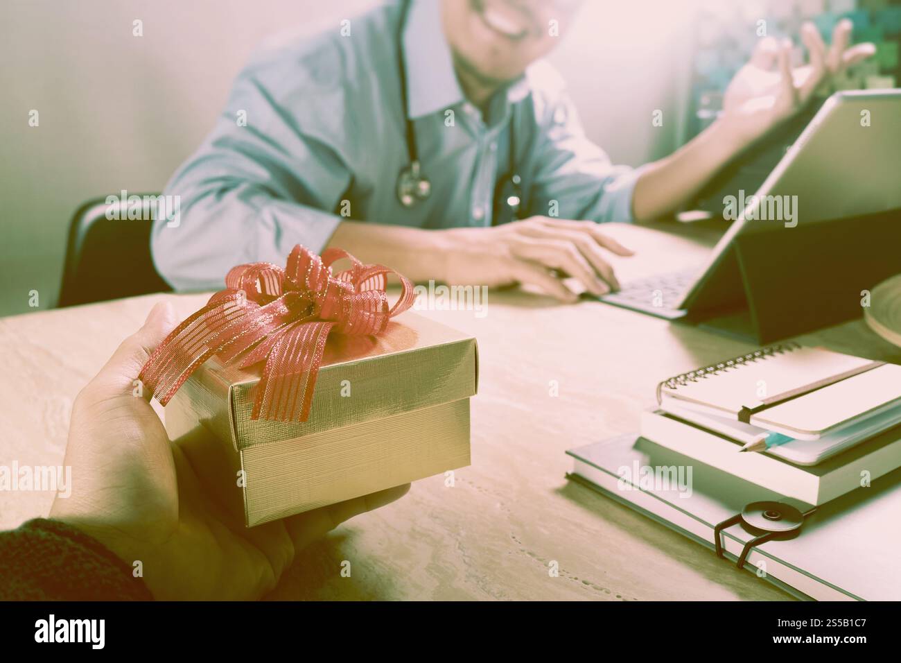 Gift Giving.Patient hand or Team giving a gift to a surprised Medical ...