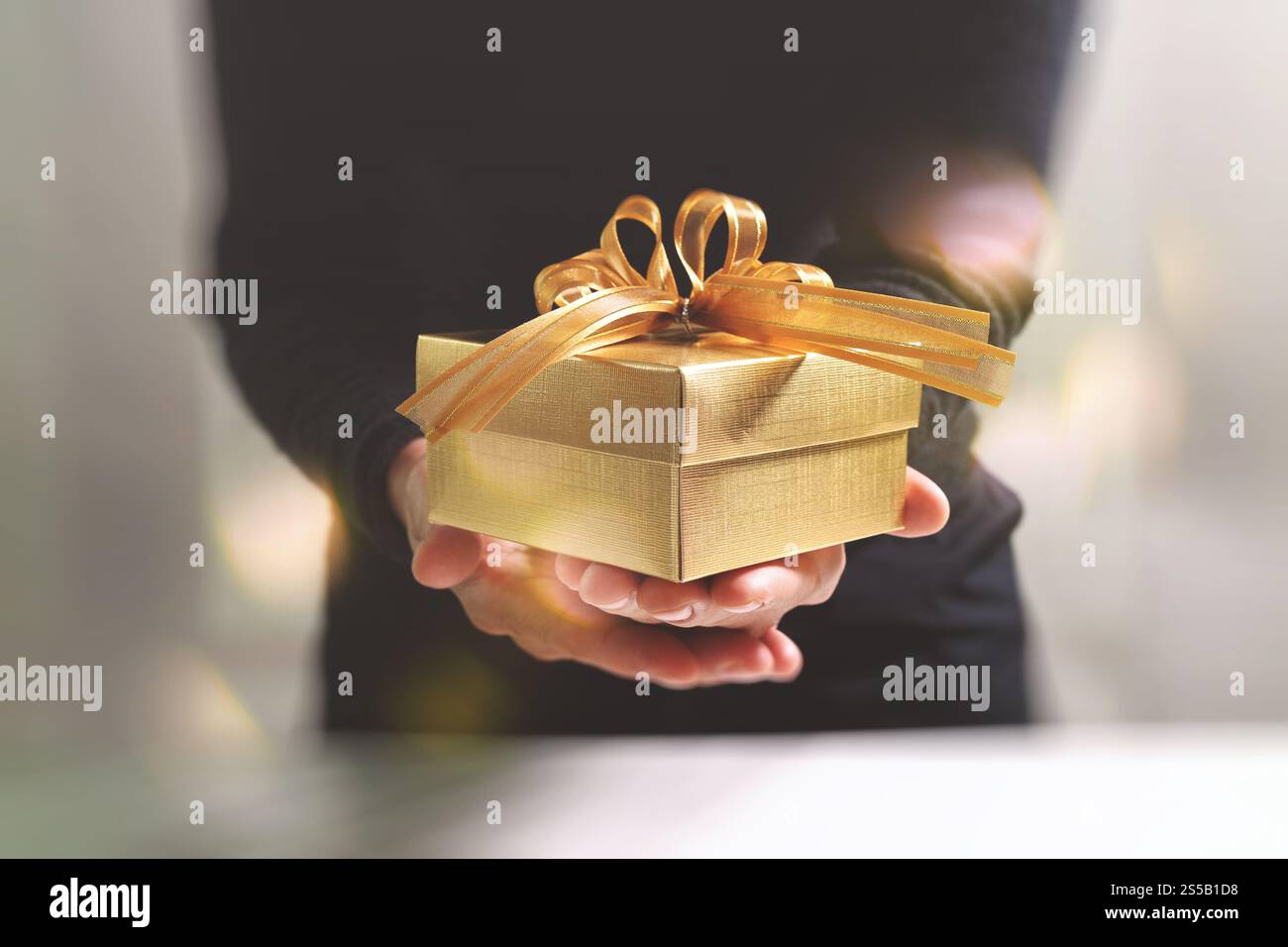 gift giving,man hand holding a gold gift box in a gesture of giving ...