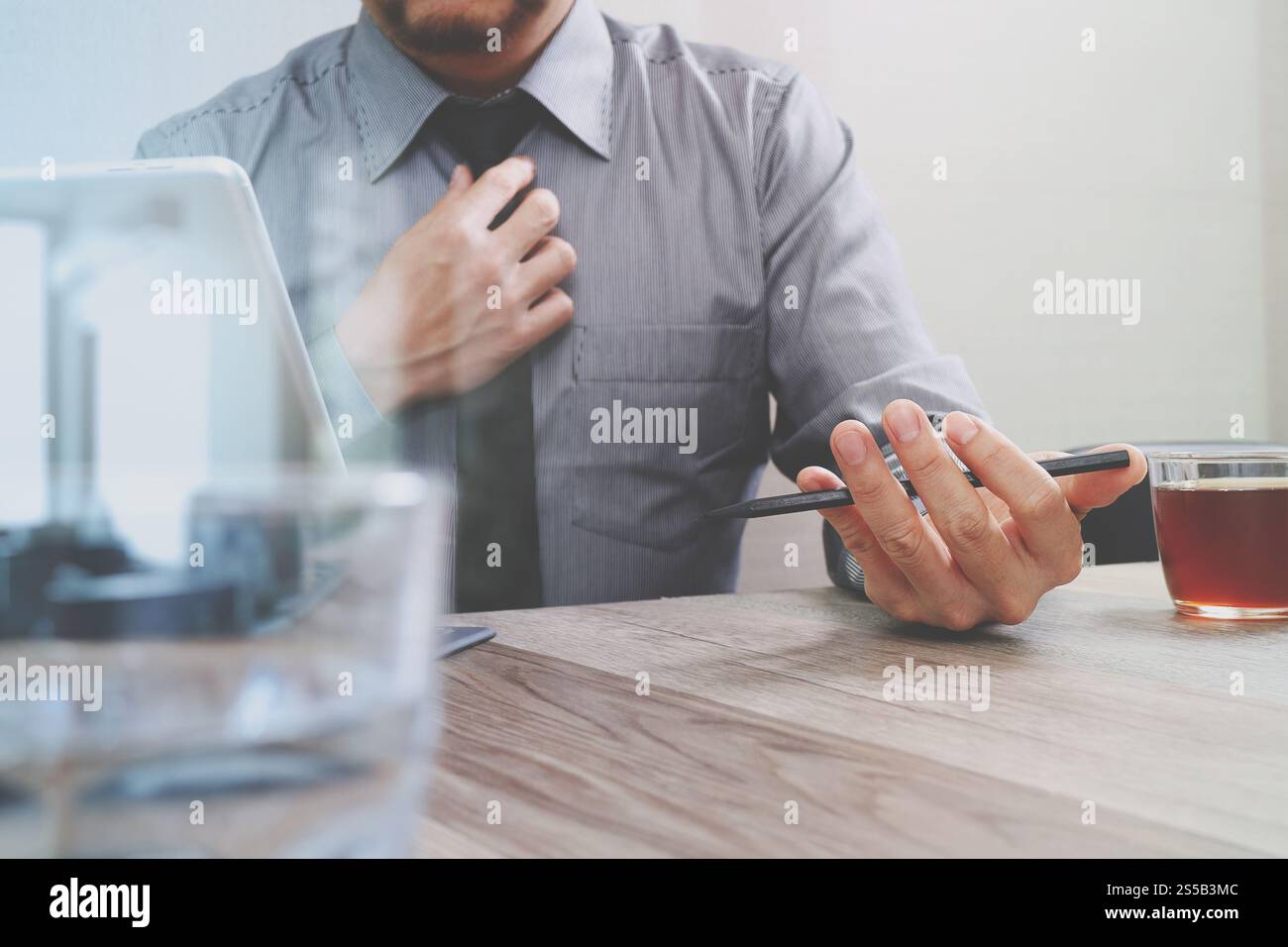 success businessman hand using smart phone,digital tablet docking smart keyboard,coffee cup on ...