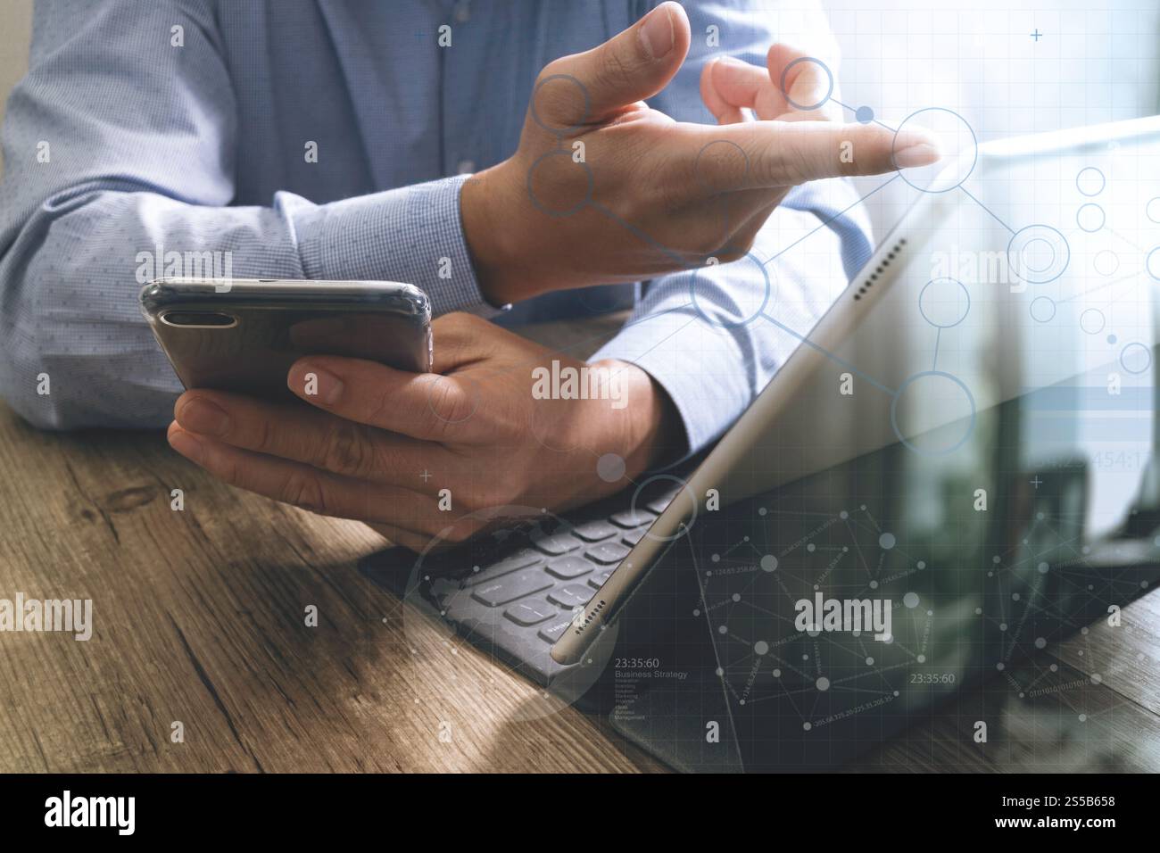 success businessman hand using smart phone,digital tablet docking smart keyboard,on wooden desk ...