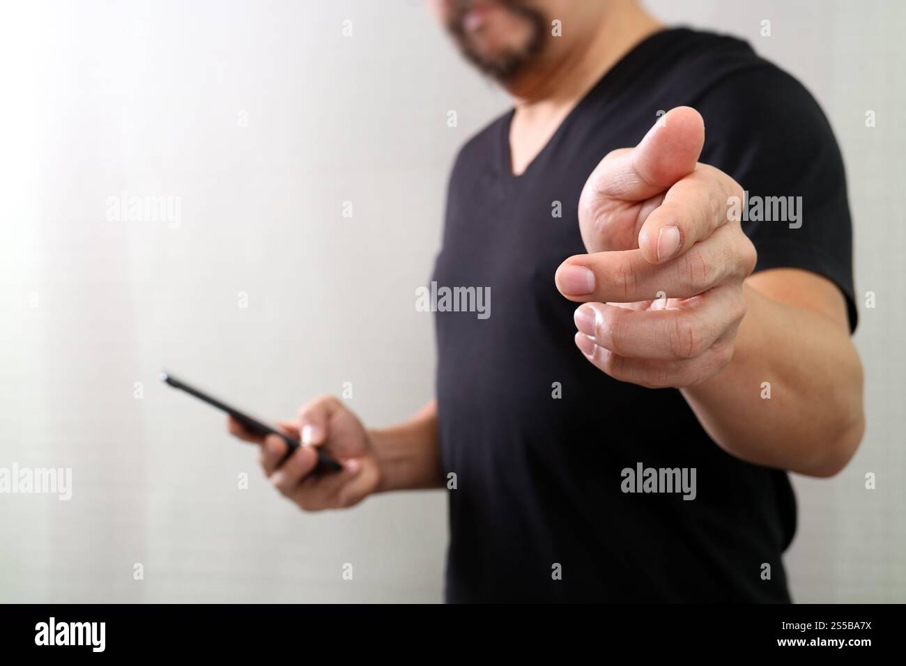 Designer hand pressing an imaginary button,holding smart phone,digital ...