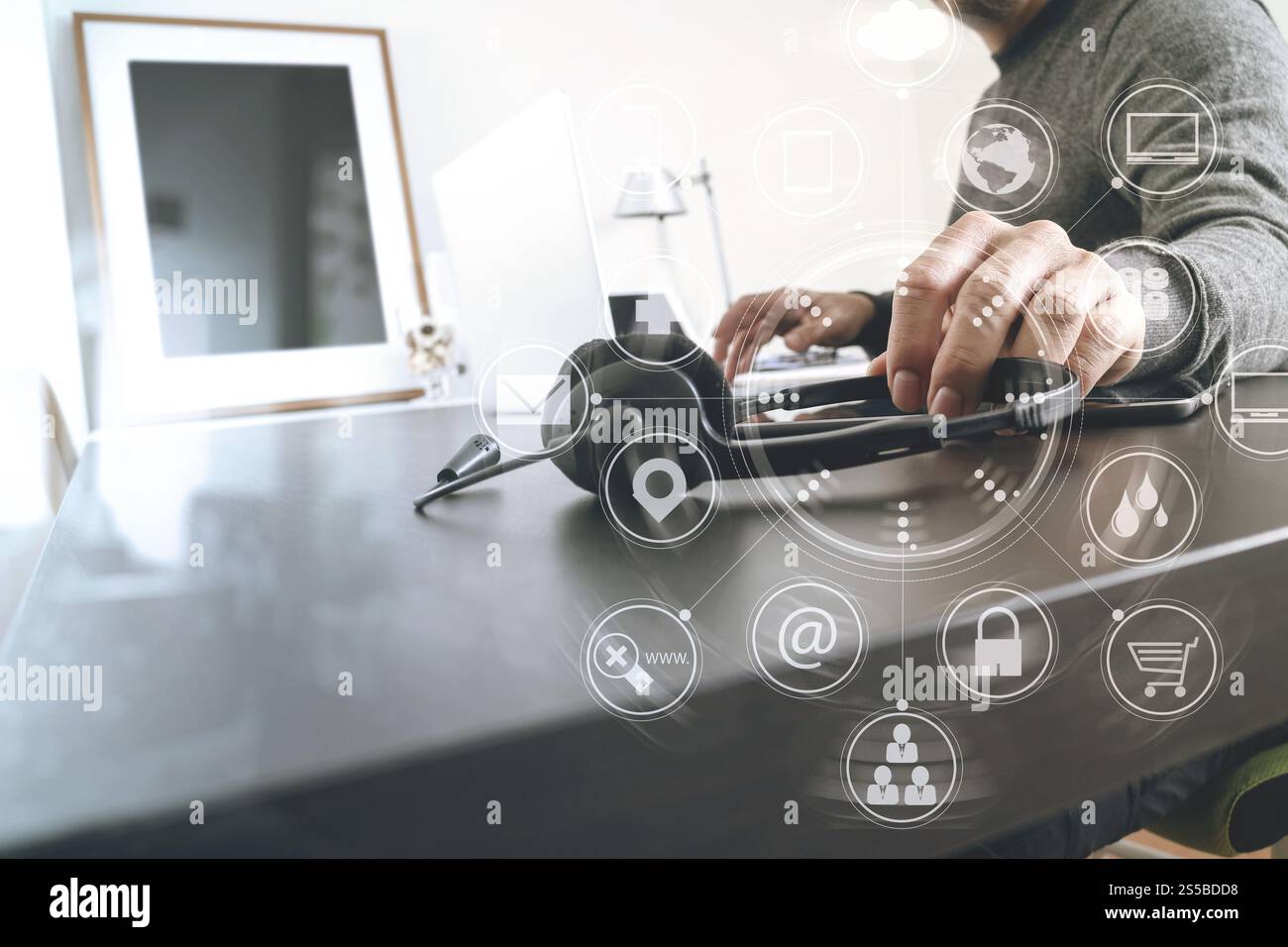 Man using VOIP headset with latop computer on desk in modern office as ...