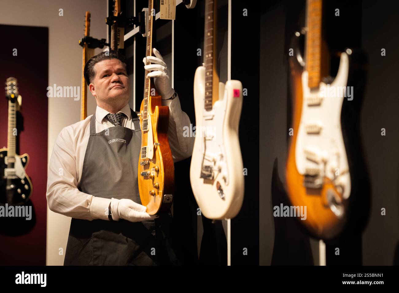 An art handler holds a 1959 Gibson Les Paul known as 'Yardburst' during ...