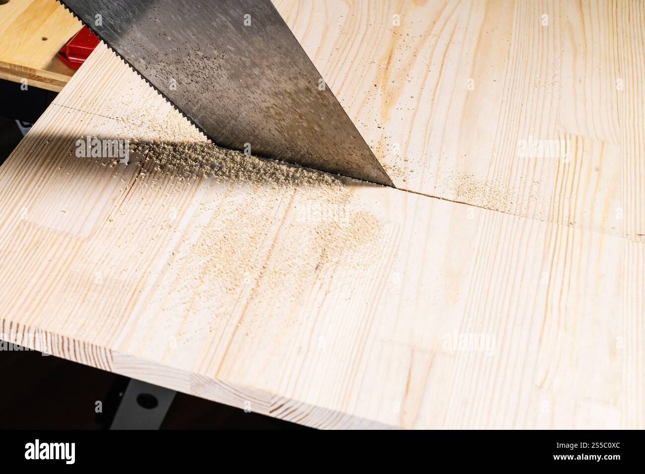 hand saw blade sawing wooden board close up on workbench at home Stock ...