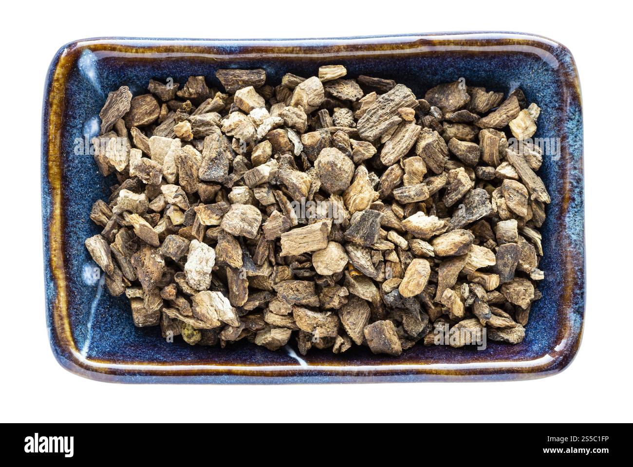 top view of chopped dried burdock roots in bowl isolated on white ...