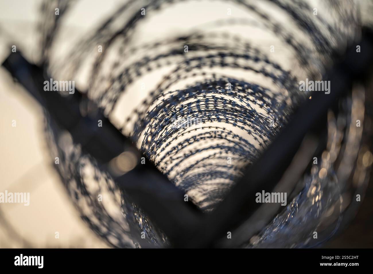 Symbolic image of security, S-wire coils, NATO wire, on a fence crown ...