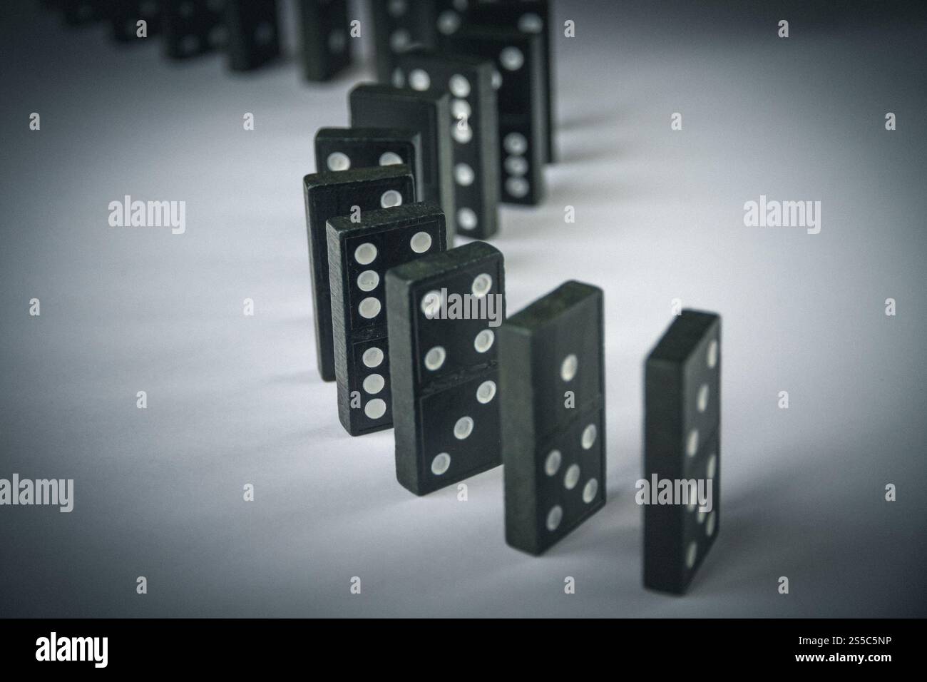 Black dominoes chain on a table background. Domino effect concept ...