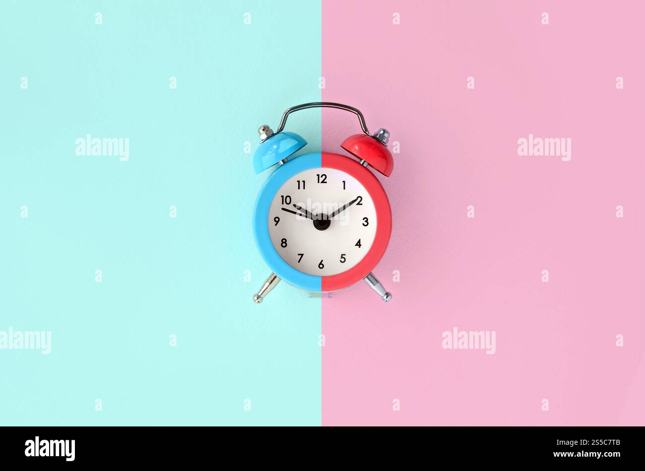 The time is at the turn of the deadline. A small color alarm clock is ...