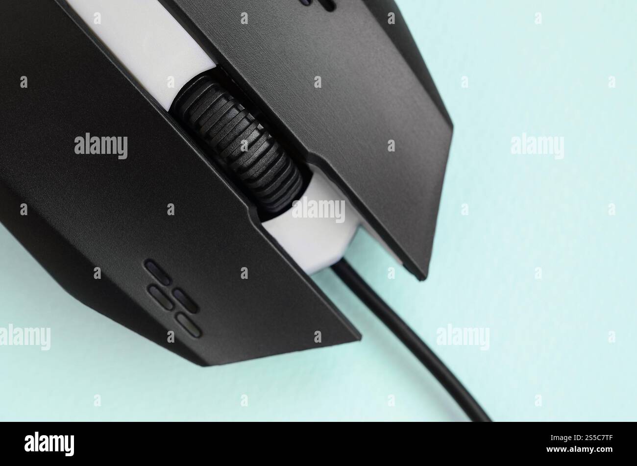 Closeup of a black gaming optical mouse on a blue background. Device ...
