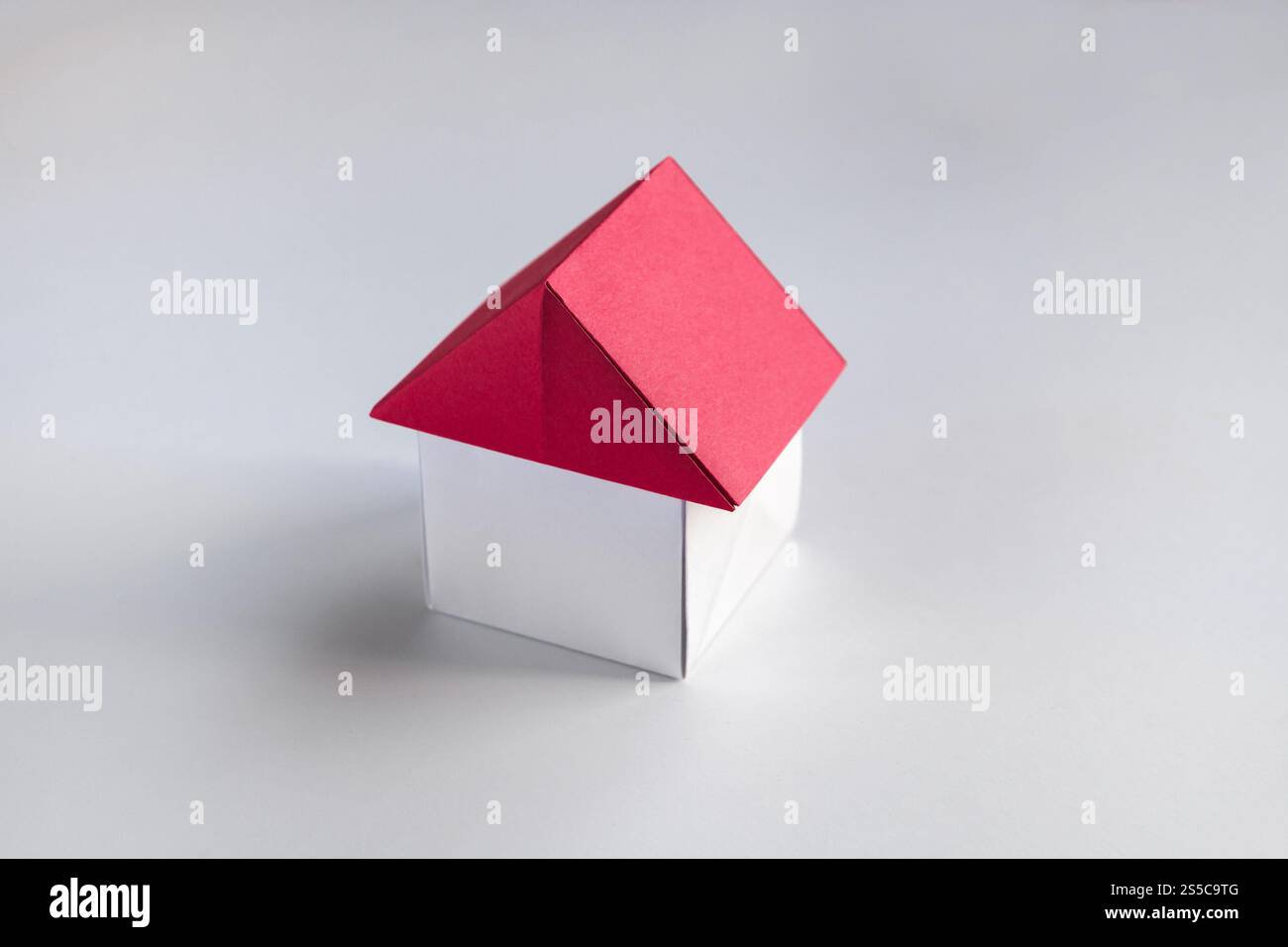 White and red paper house origami isolated on a blank background. White ...