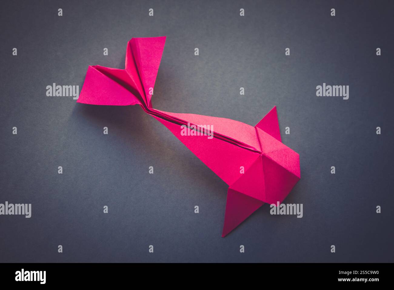 Pink paper fish origami isolated on a blank grey background. Pink paper ...