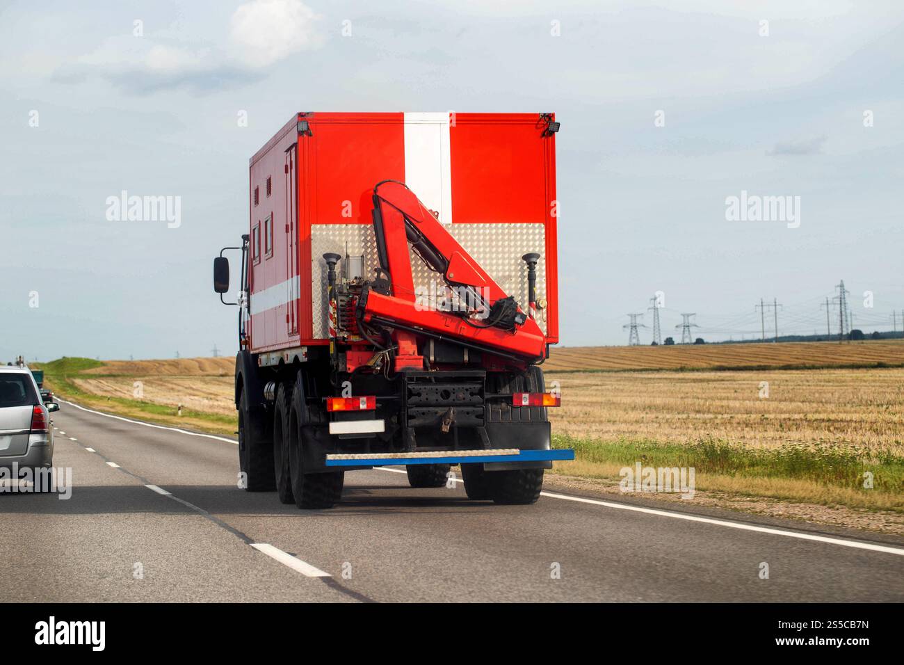 A special fire truck with a manipulator crane driving along a highway ...
