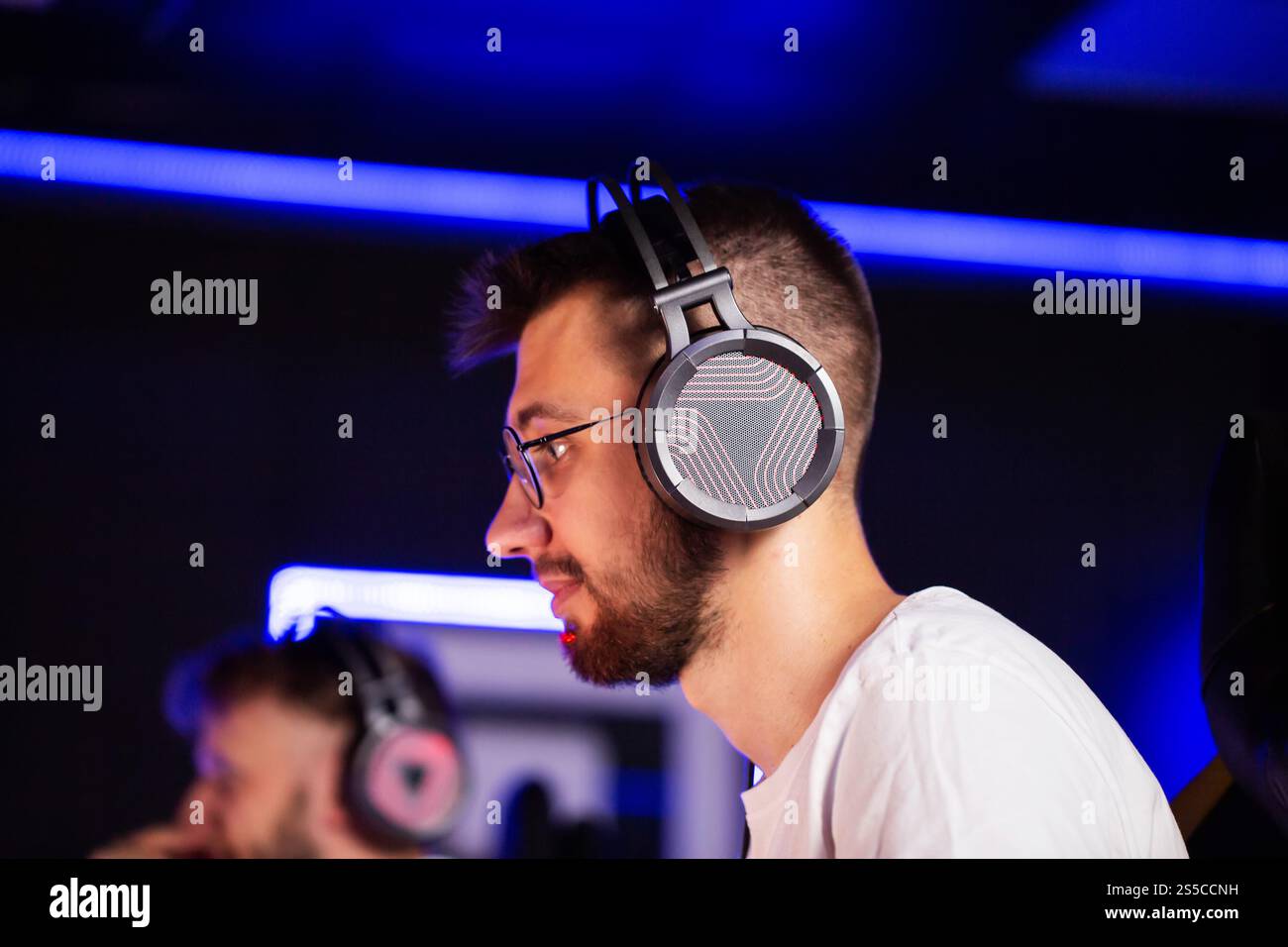 Joyful gamer emotionally plays tight arcade racing, facial expressions ...