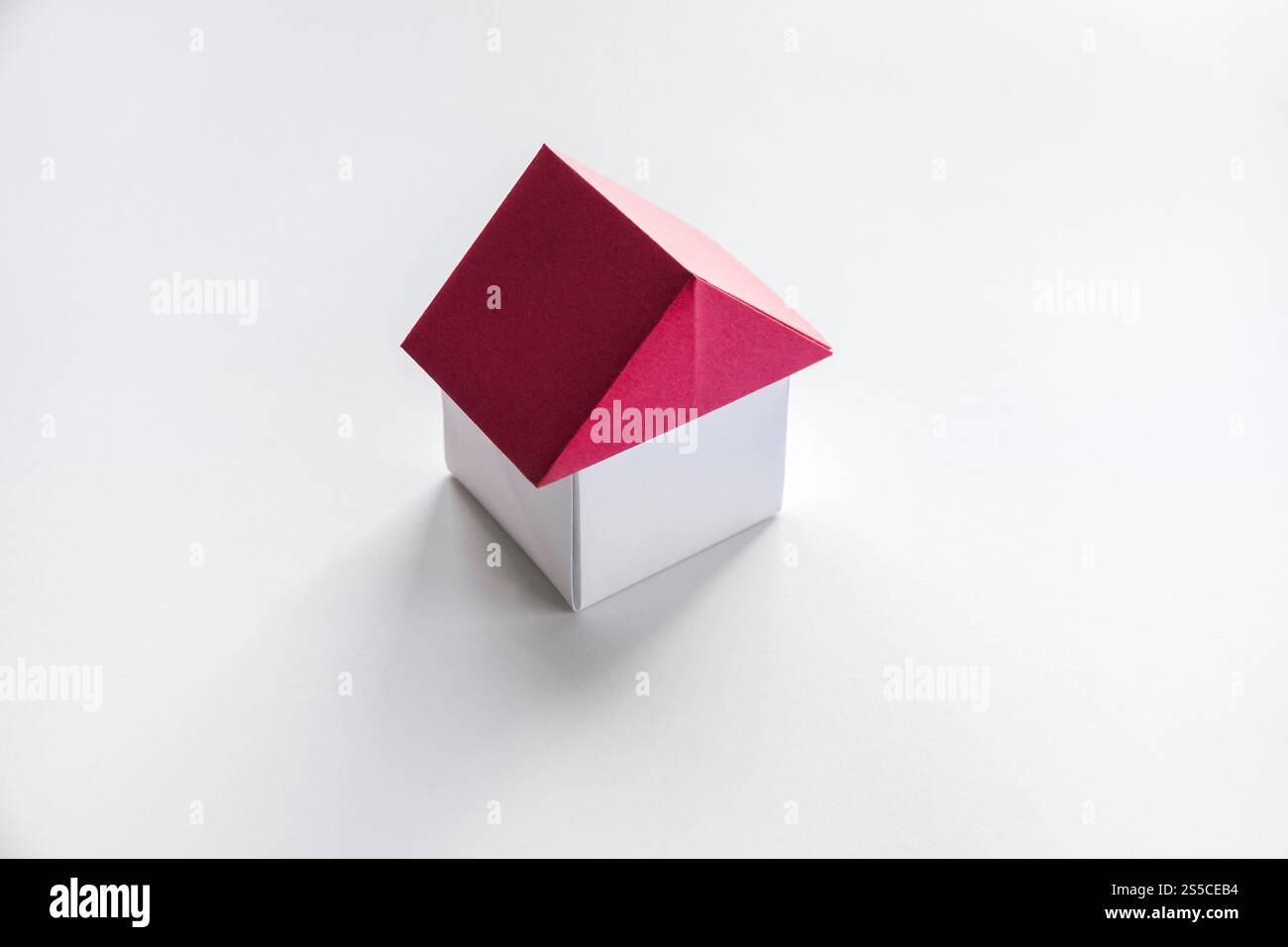White and red paper house origami isolated on a blank background. White ...