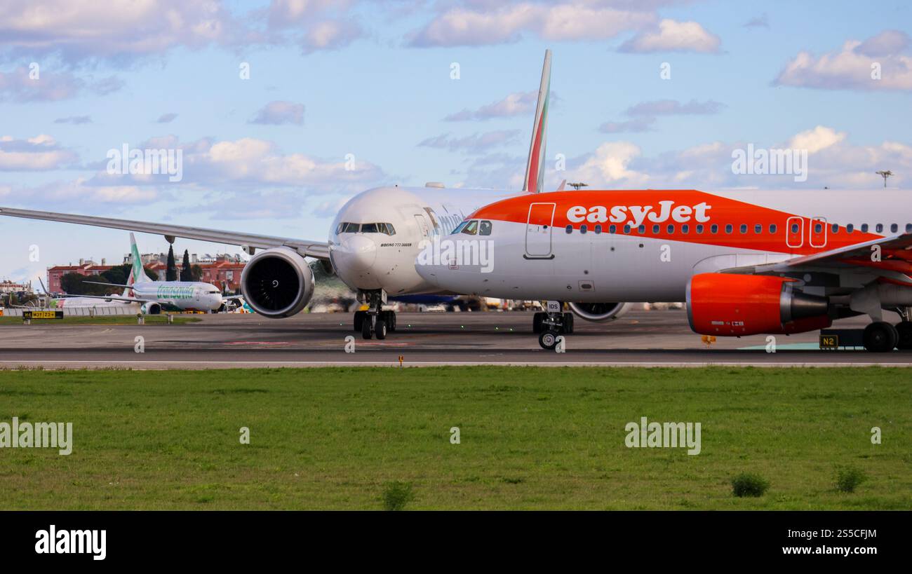 Easyjet airbus a320 and an emirates boeing 777 taxiing at lisbon ...