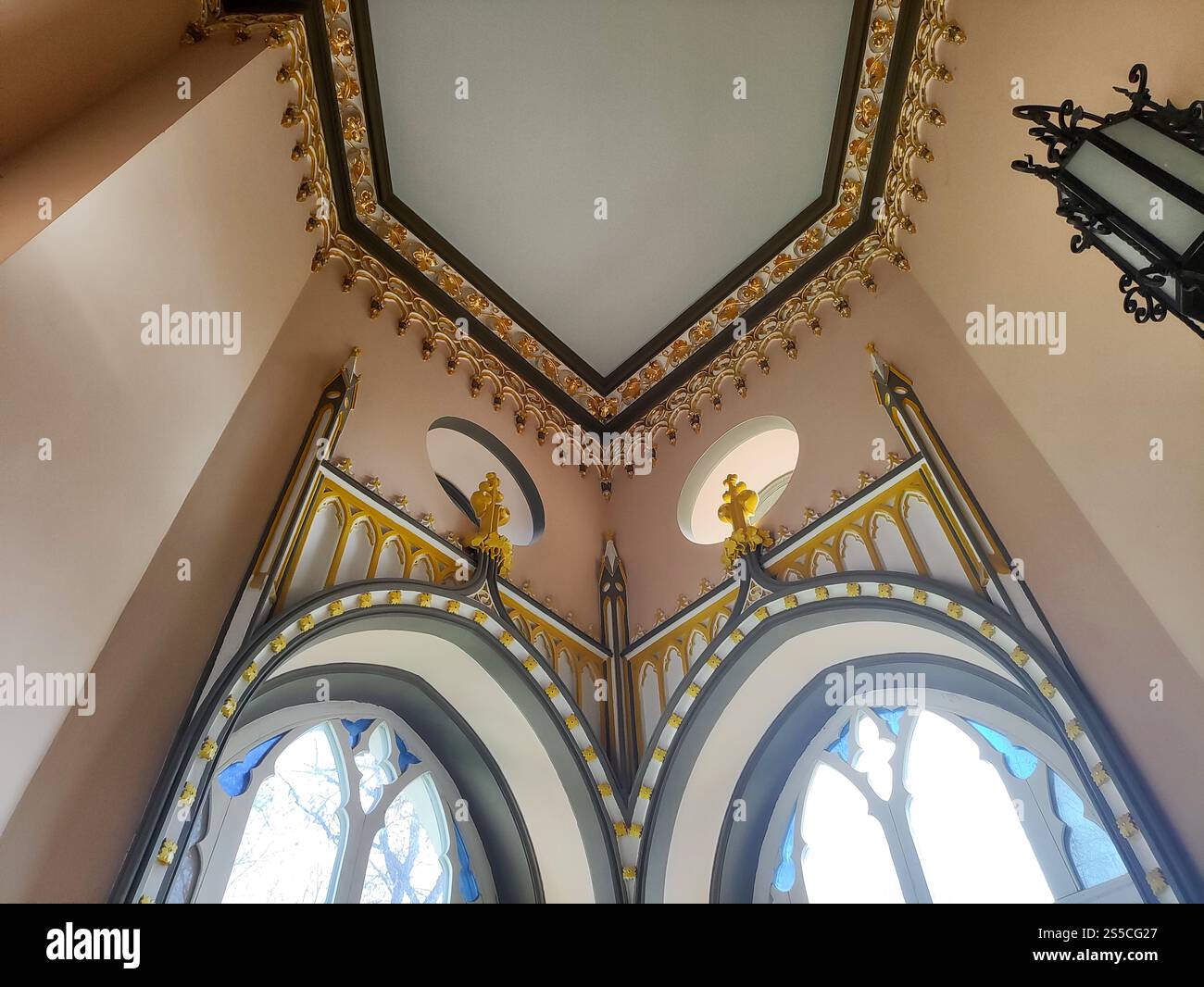Two windows with multi-colored glass and patterns on the ceiling and ...