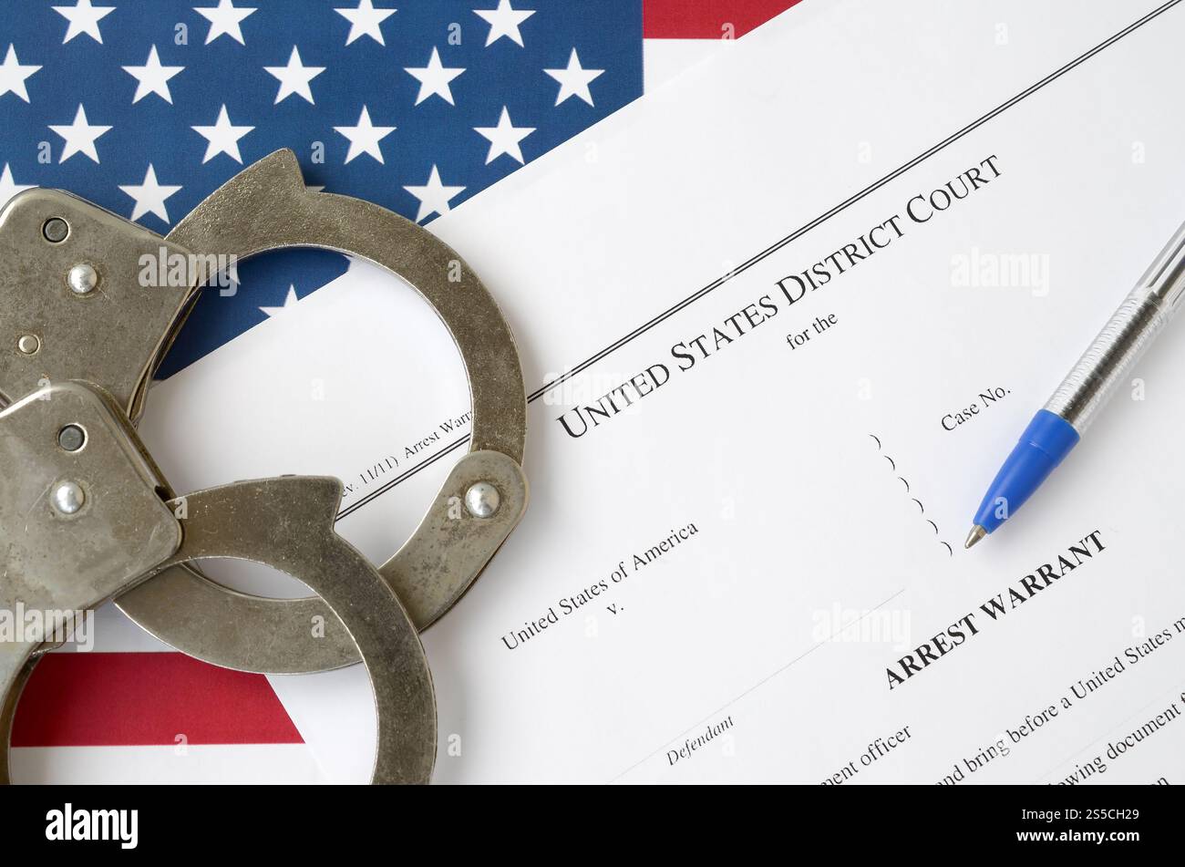 District Court Arrest Warrant court papers with handcuffs and blue pen ...