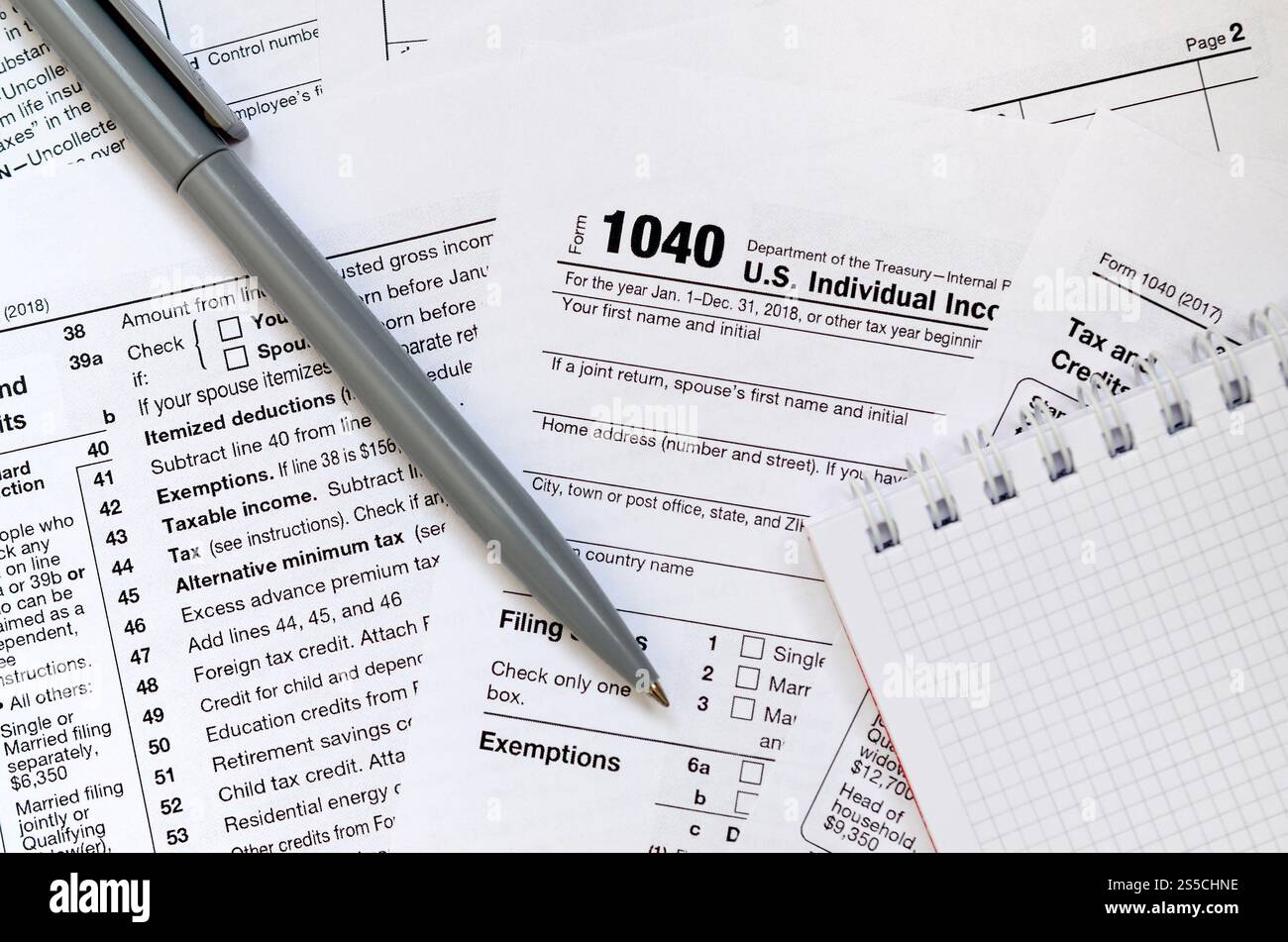 The pen and notebook is lies on the tax form 1040 U.S. Individual ...