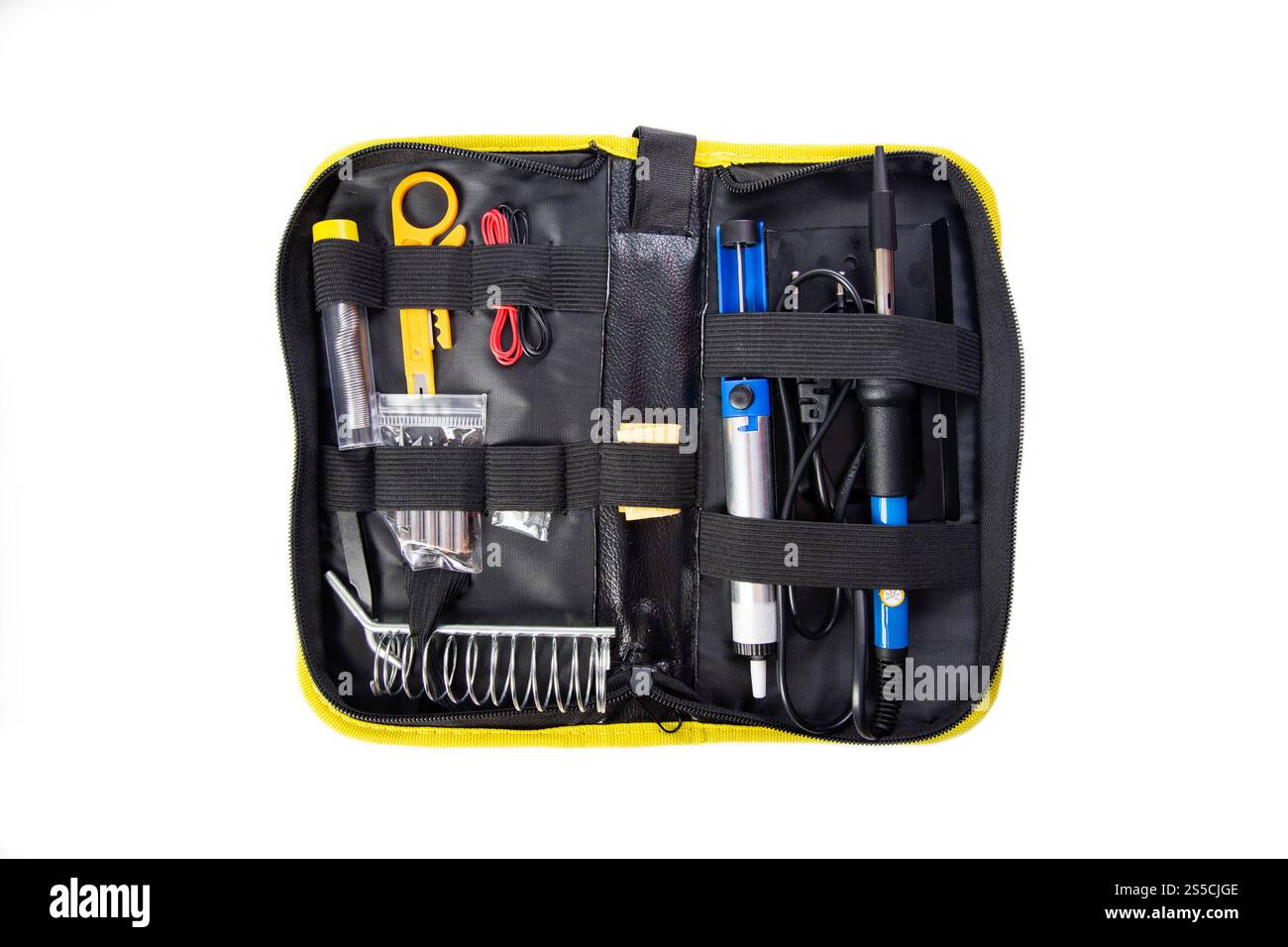 Soldering kit in a case with an electric soldering iron and solder on a ...