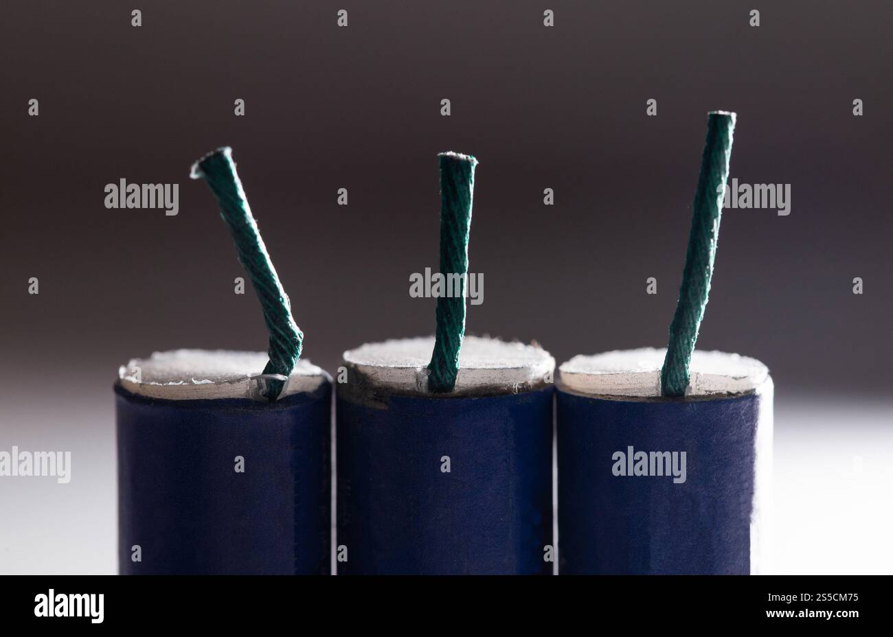 Three blue firecrackers with a wick, close-up. Safety concept for ...