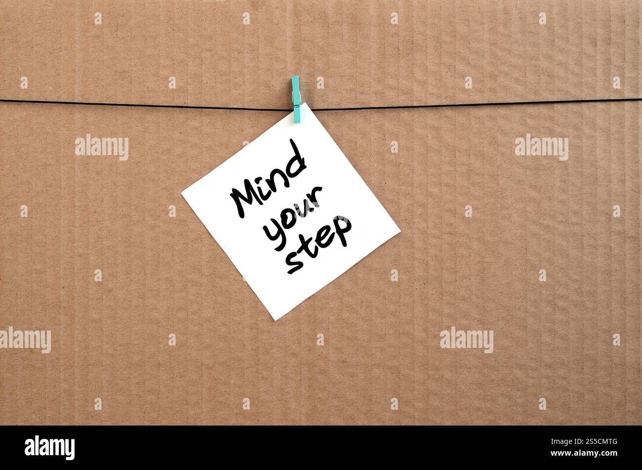 Mind your step. Note is written on a white sticker that hangs with a ...