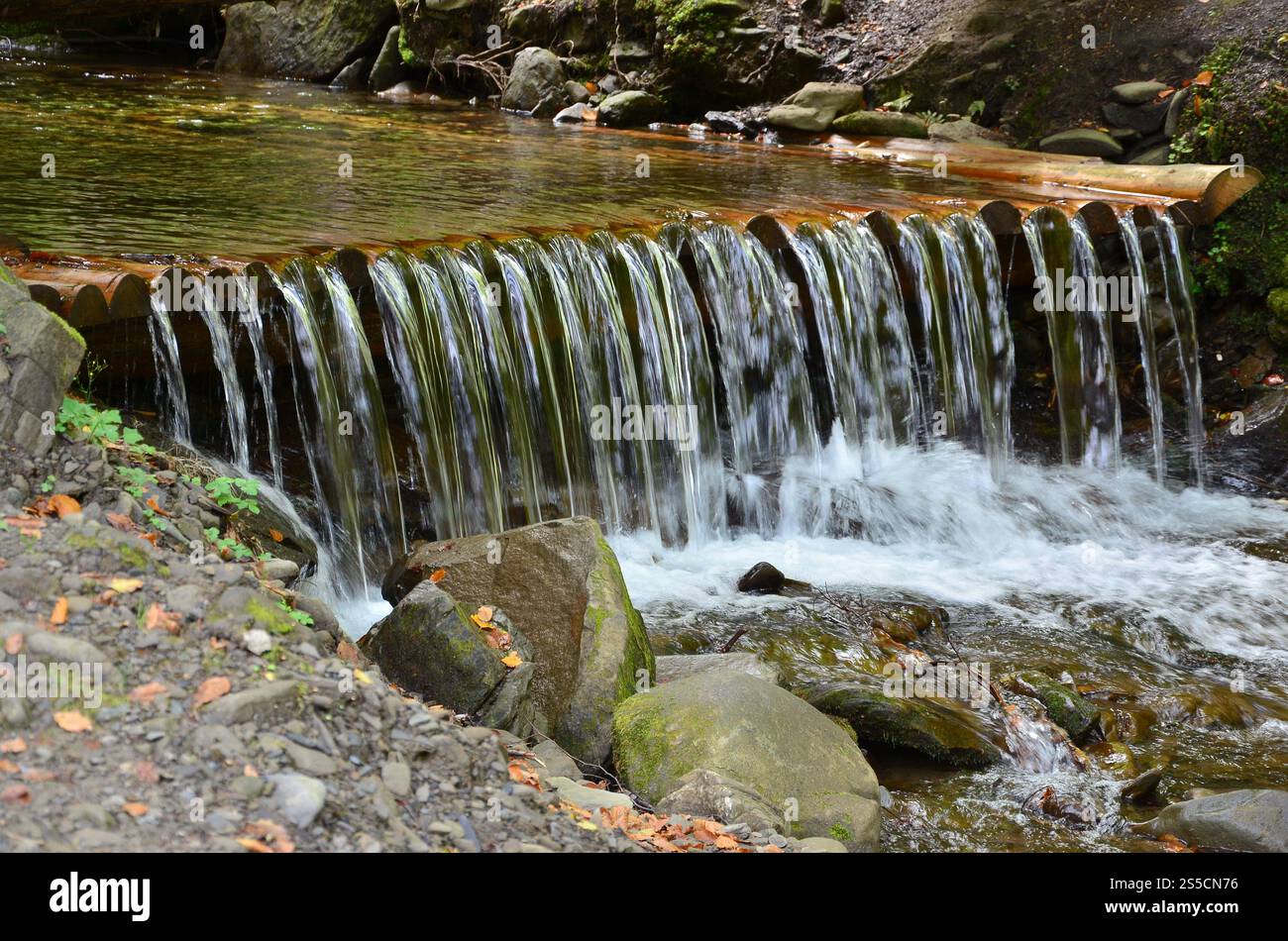 Handmade wooden water drains from small treated beams. A beautiful ...