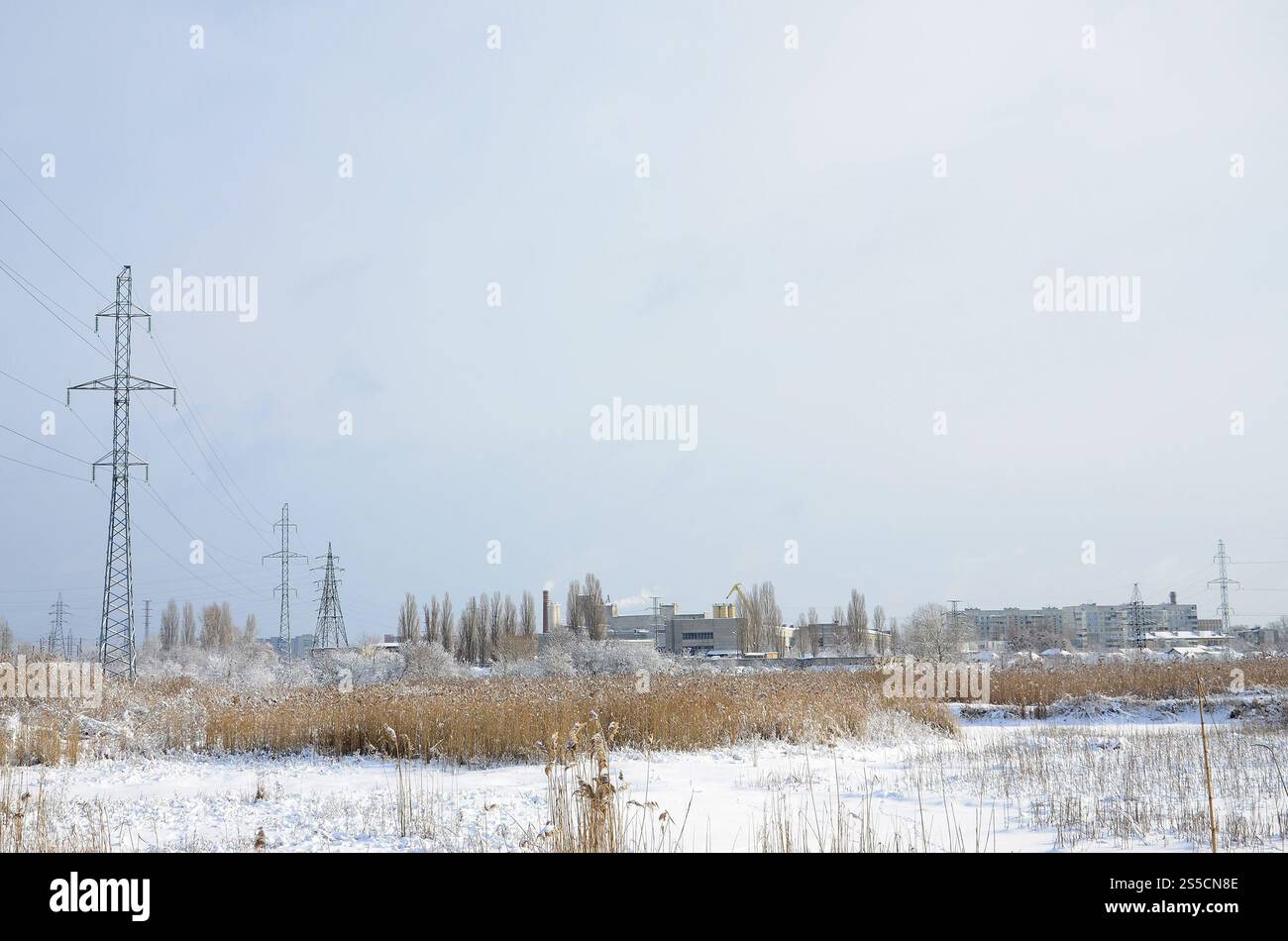 The power line tower is located in a marshy area, covered with snow ...