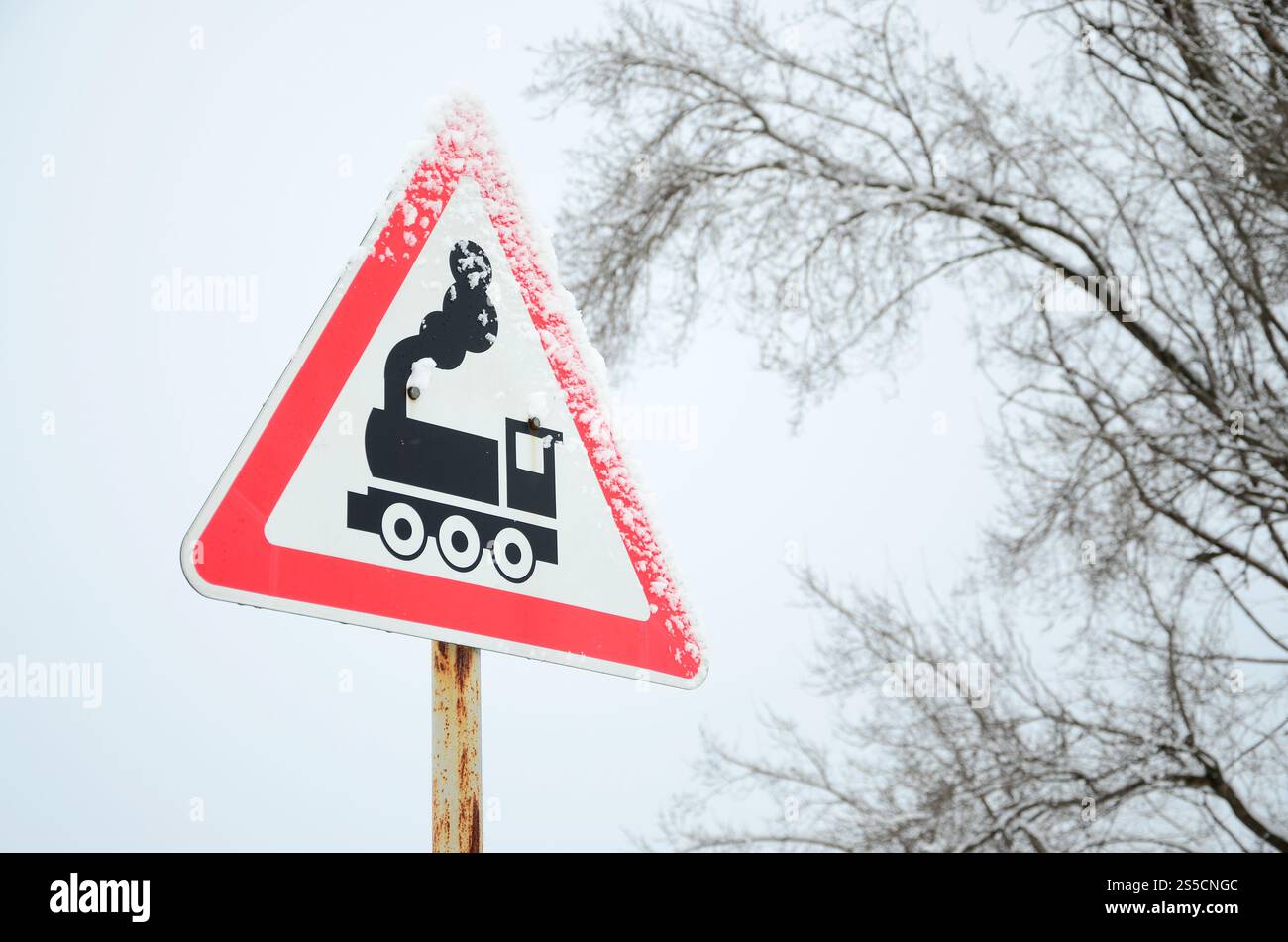 Railway crossing without barrier. A road sign depicting an old black ...