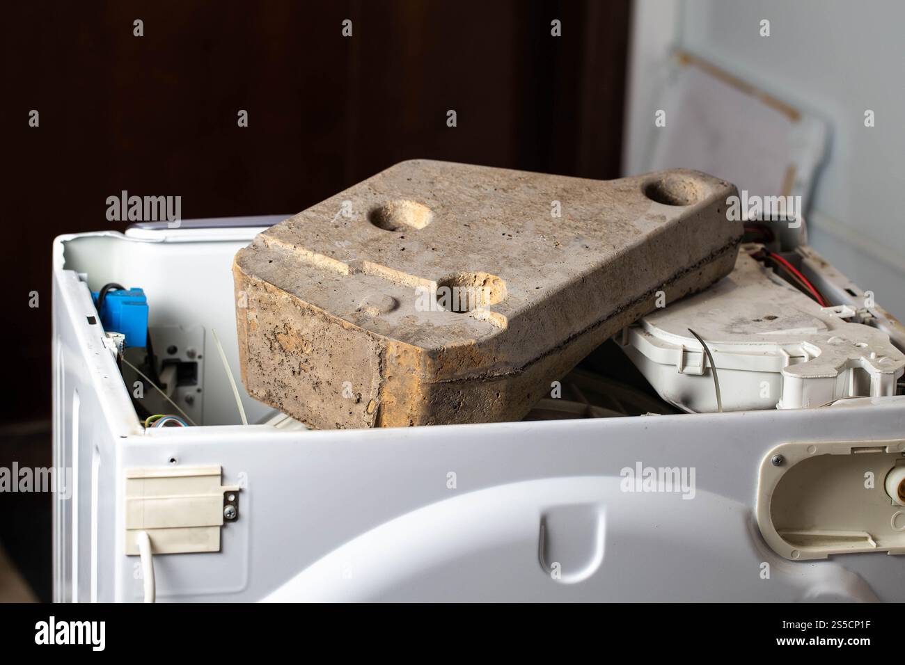 Unscrewed counterweight stone in a washing machine. The concept of ...