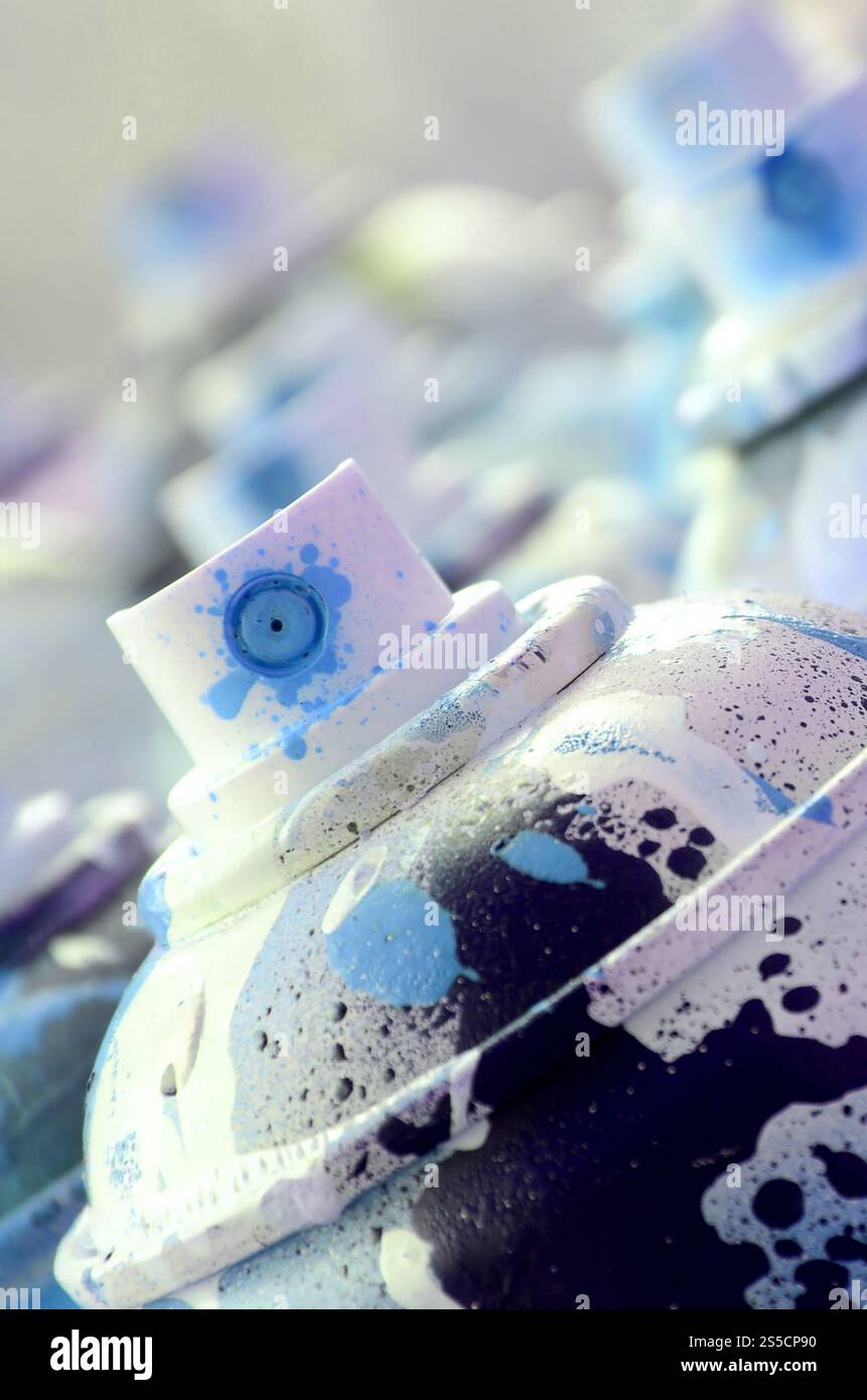 A lot of dirty and used aerosol cans of bright blue paint. Macro ...