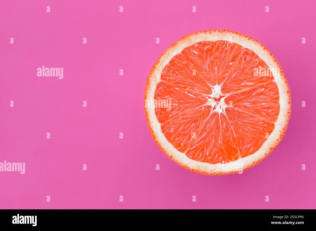 Top view of an one grapefruit slice on bright background in purple ...