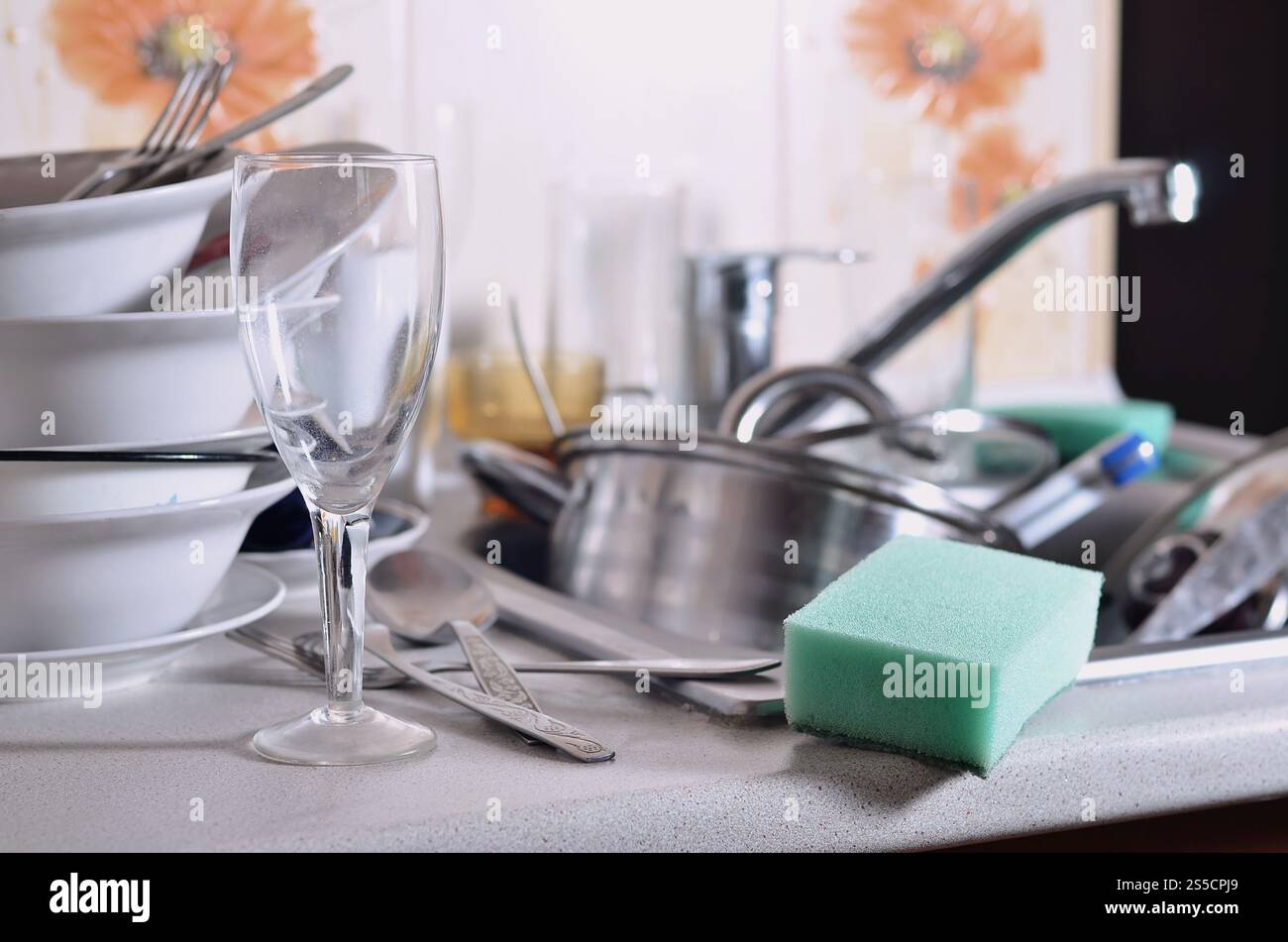 A huge pile of unwashed dishes in the kitchen sink and on the ...