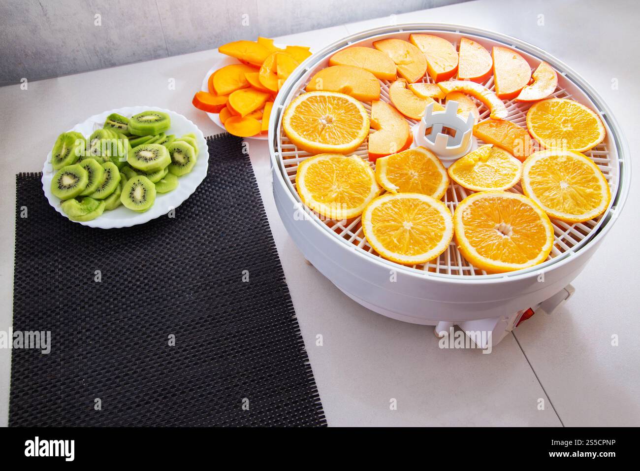 Drying oranges, kiwis and persimmons for the winter in a dryer ...