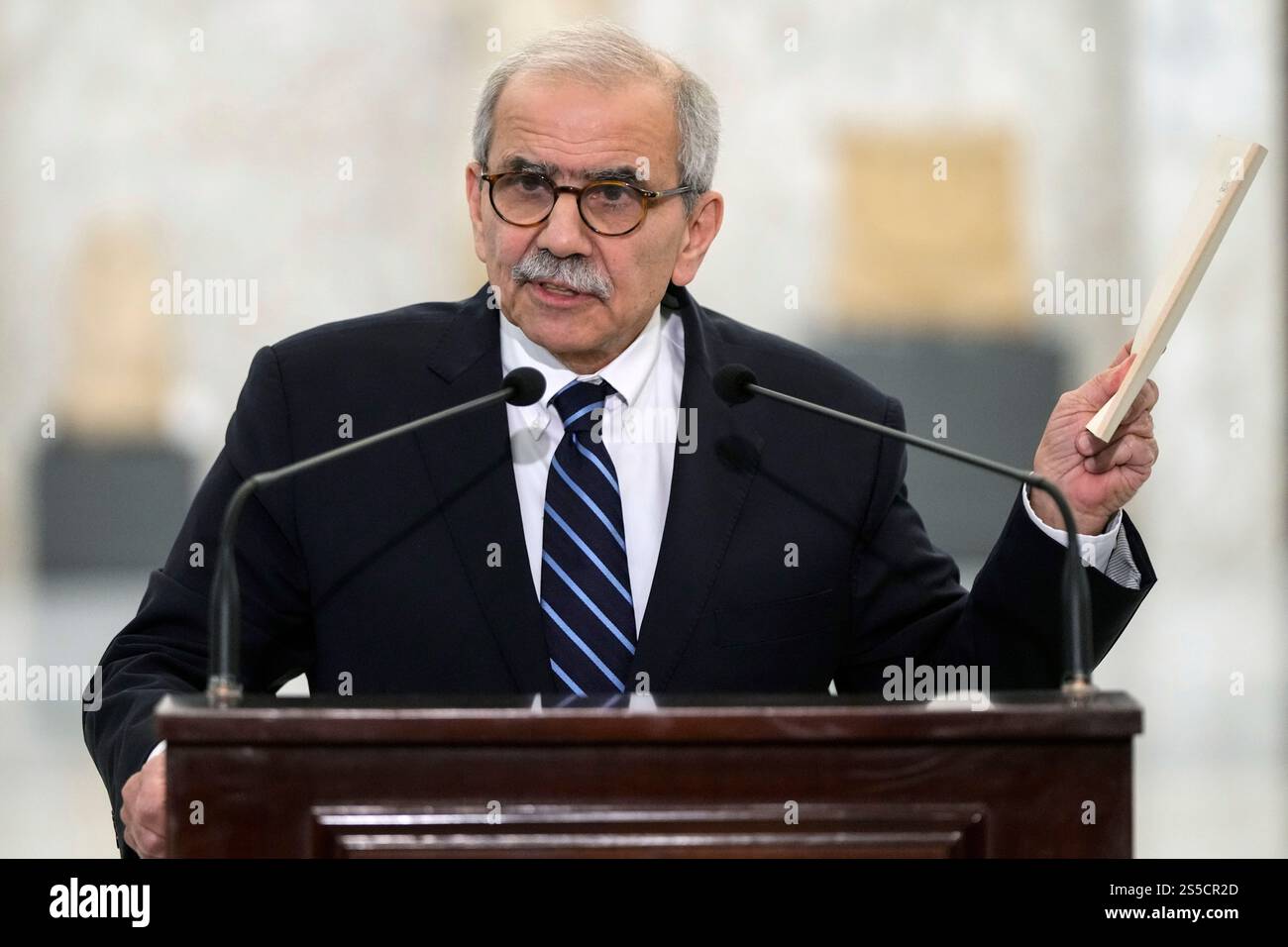 Lebanese Prime Minister-designate Nawaf Salam holds up a copy of the ...