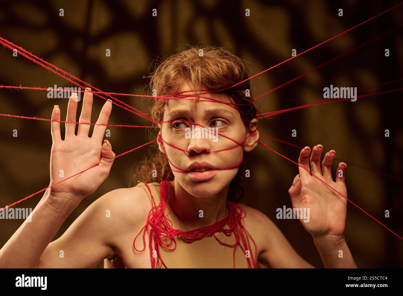 Medium close up of scared woman touching sharp thorns made of red threads Stock Photo - Alamy
