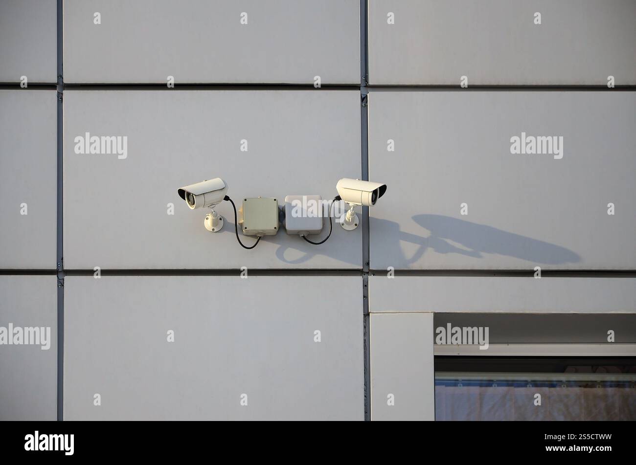 White surveillance camera built into the metal wall of the office ...
