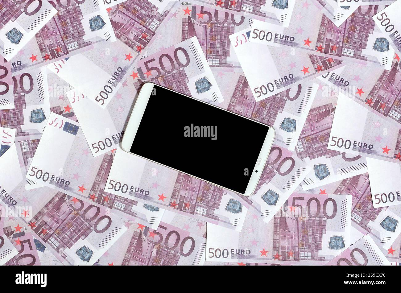 Purple 500 euro money bills and a smartphone with black screen. Copy ...