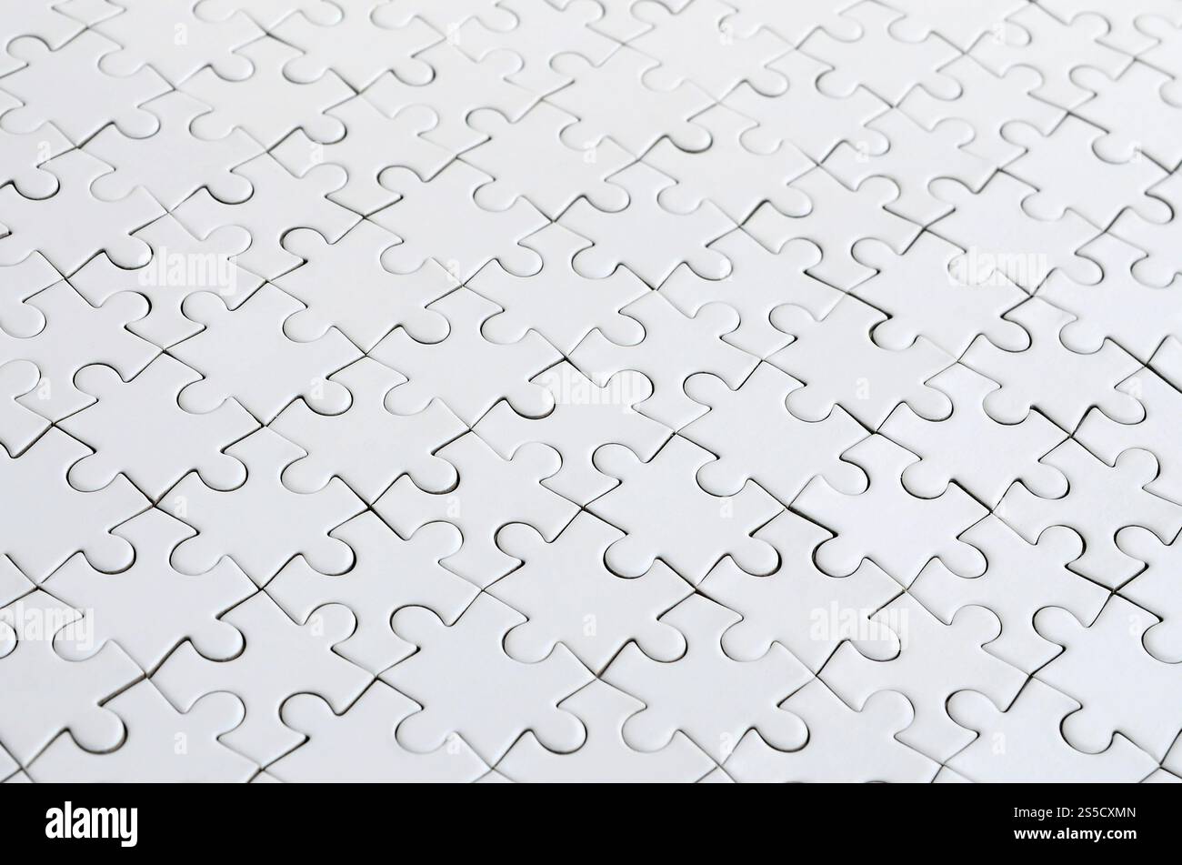 Close up of a white jigsaw puzzle in assembled state in perspective ...