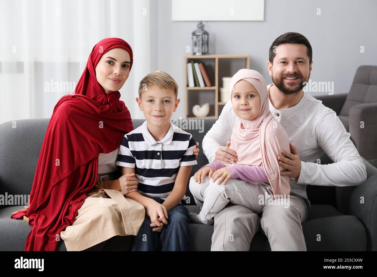 Happy Muslim family sitting on sofa at home Stock Photo - Alamy