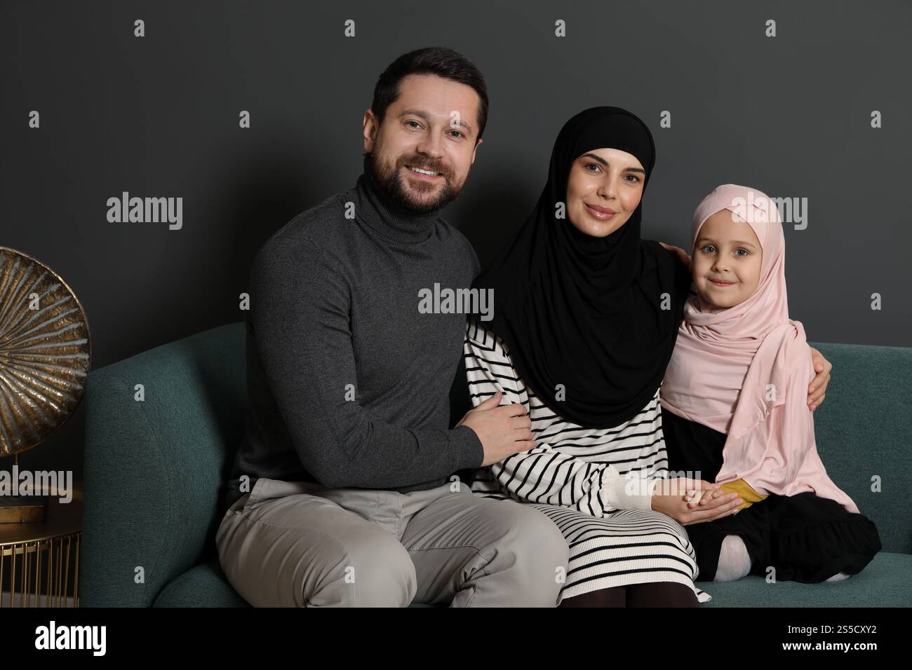 Happy Muslim family sitting on sofa at home Stock Photo - Alamy