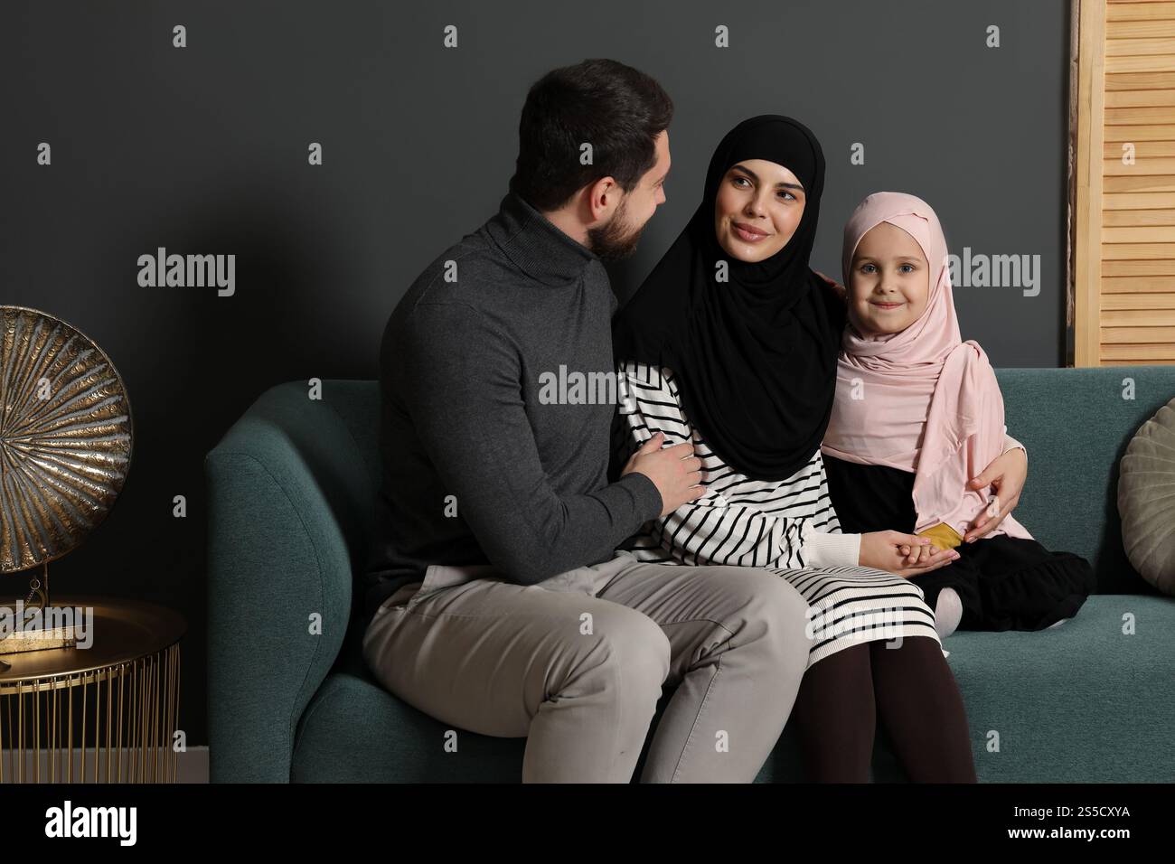 Happy Muslim family sitting on sofa at home Stock Photo - Alamy